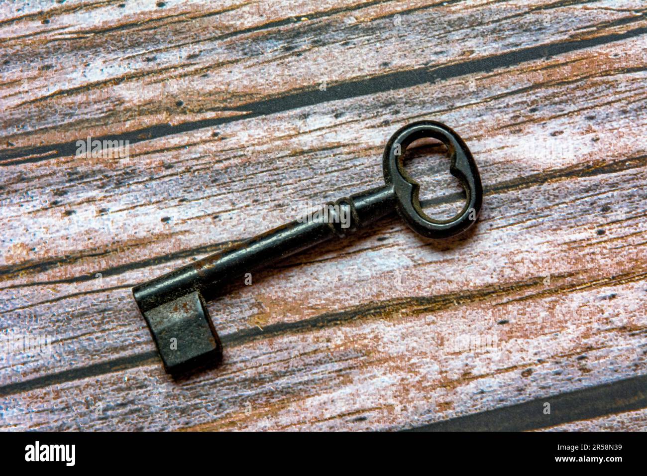 Old iron key photographed in a wooden background Stock Photo - Alamy