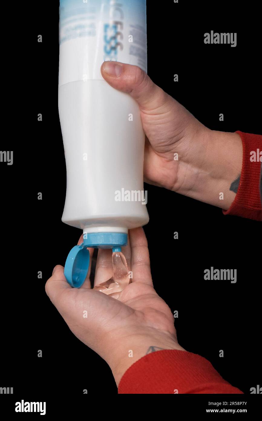 The hands of a professional barber squeeze shampoo into his hand before ...