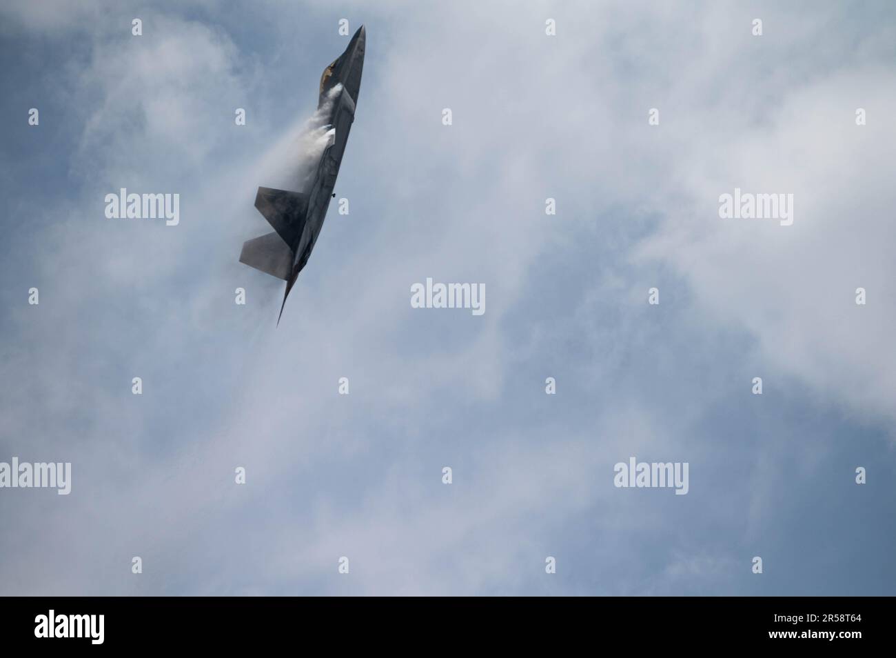 A vapor cone forms on an F-22 Raptor as it flies during the Scott Air ...