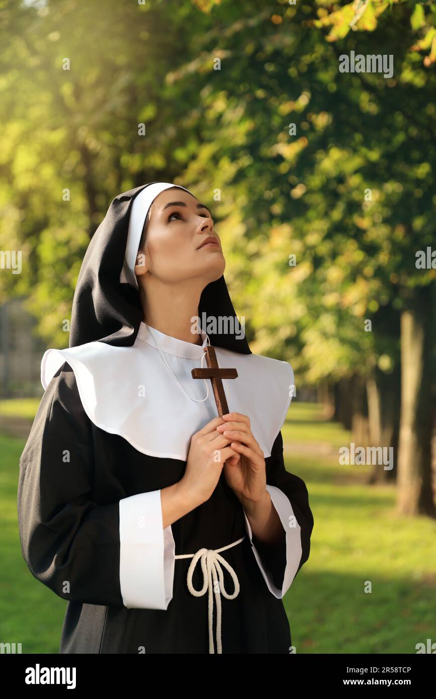 Young nun with Christian cross in park on sunny day Stock Photo - Alamy