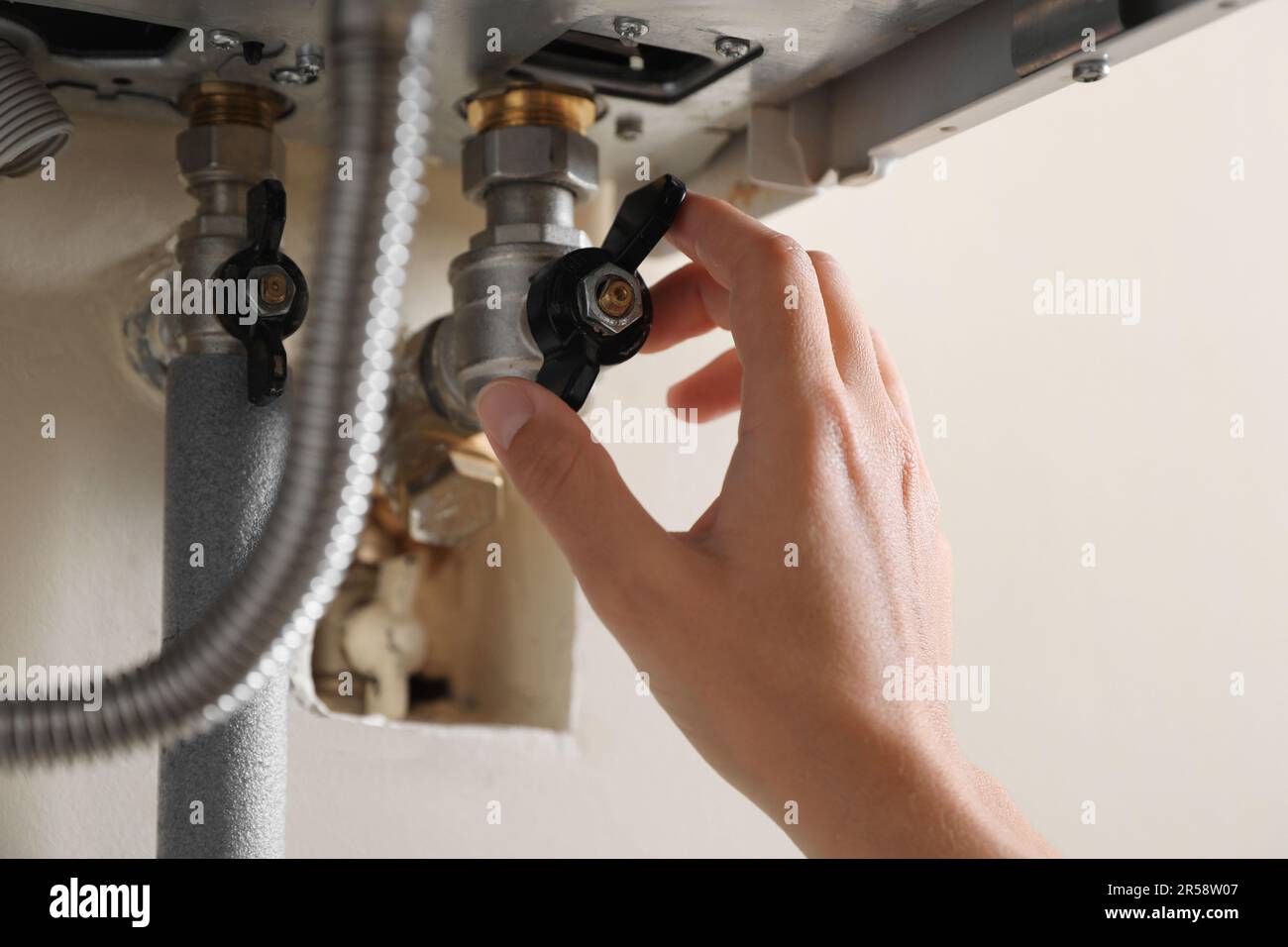 Woman turning on valve hi-res stock photography and images - Alamy