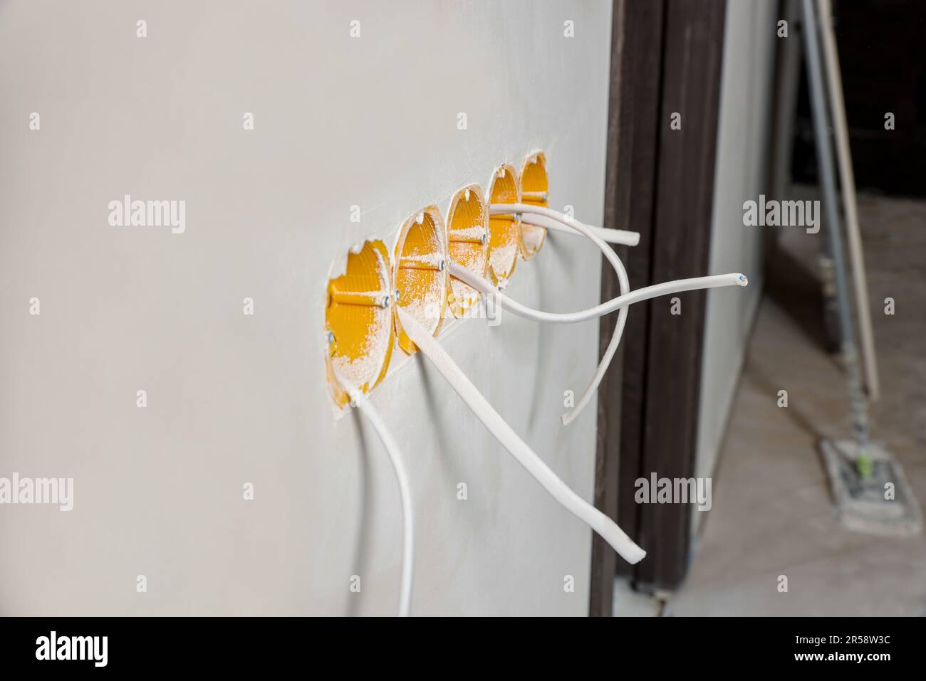 Holes for socket in white wall with cables indoors. Installation of ...