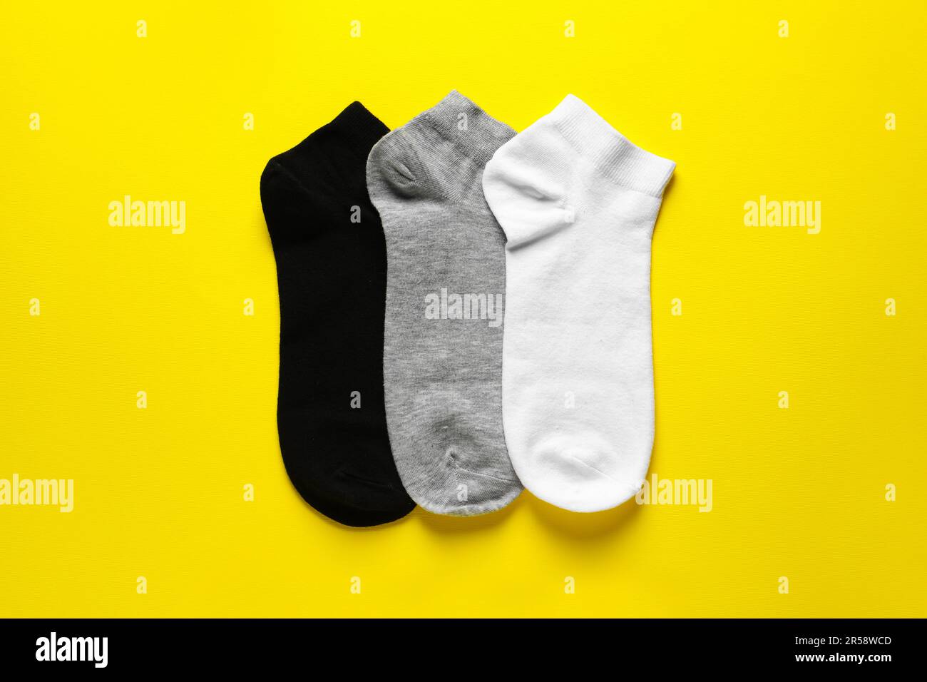 Different socks on yellow background, flat lay Stock Photo - Alamy