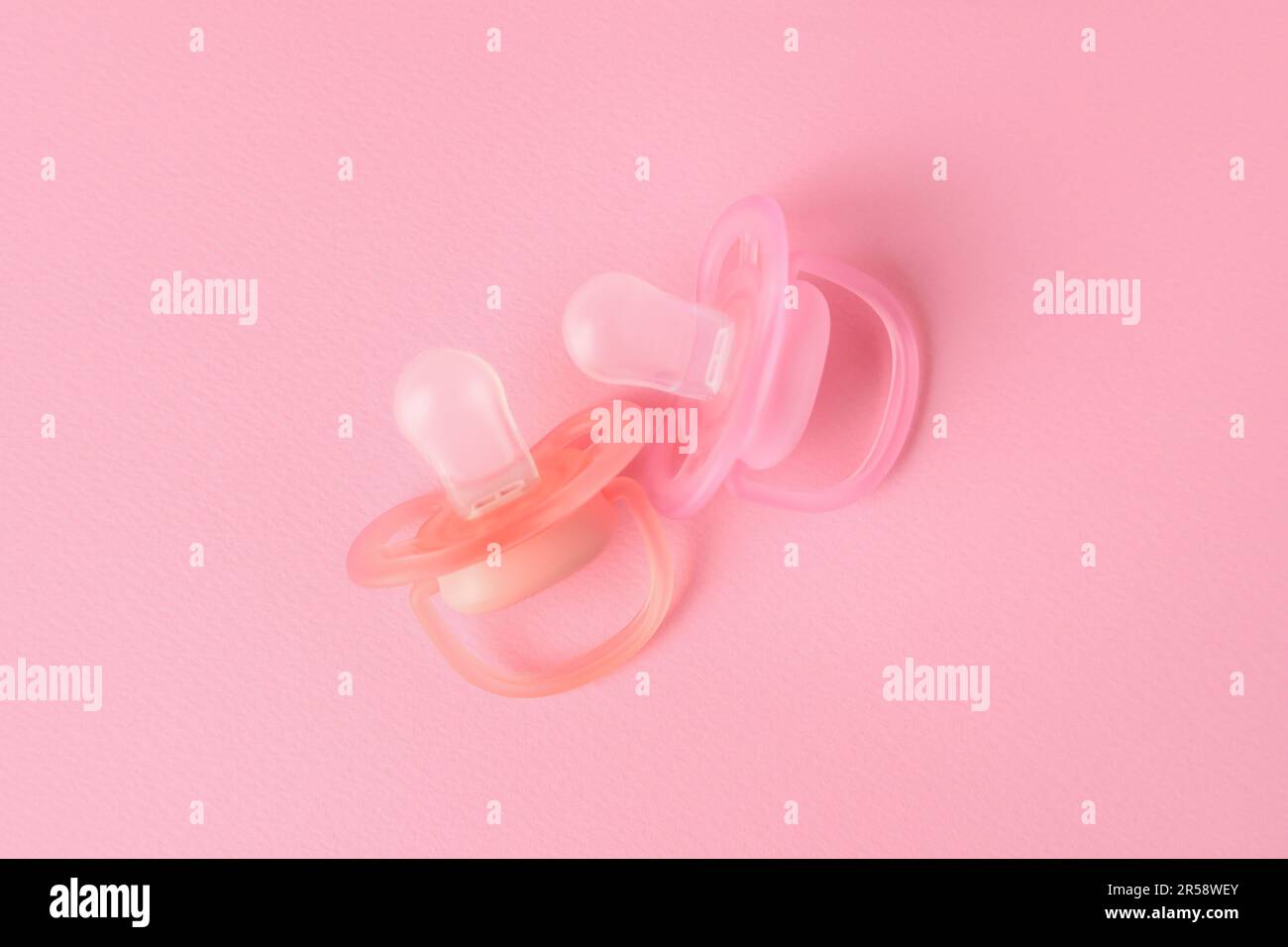 New baby pacifiers on pink background, flat lay Stock Photo - Alamy