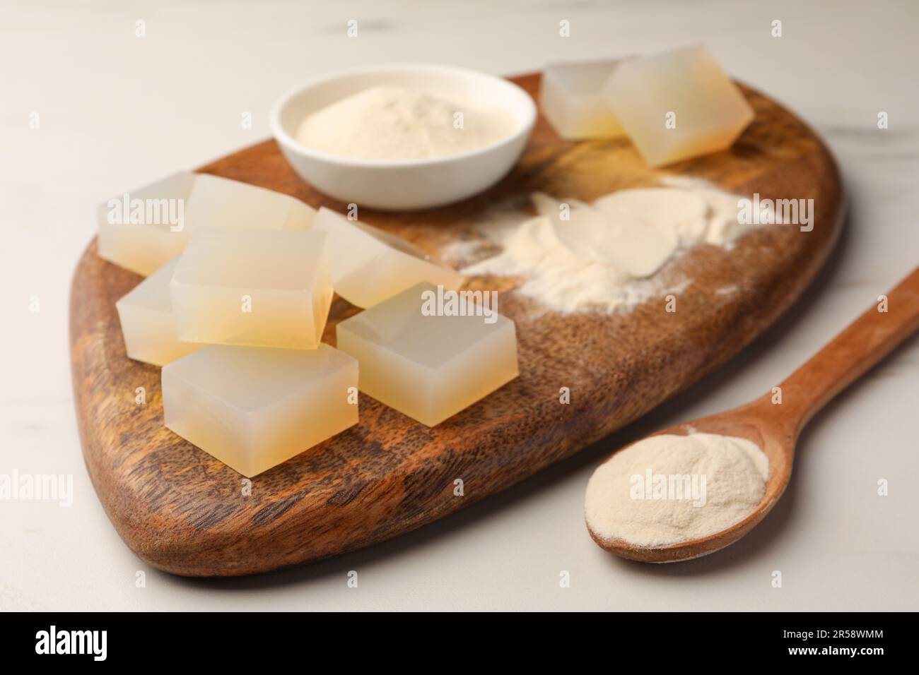Agar-agar jelly cubes and powder on white marble table, closeup Stock ...
