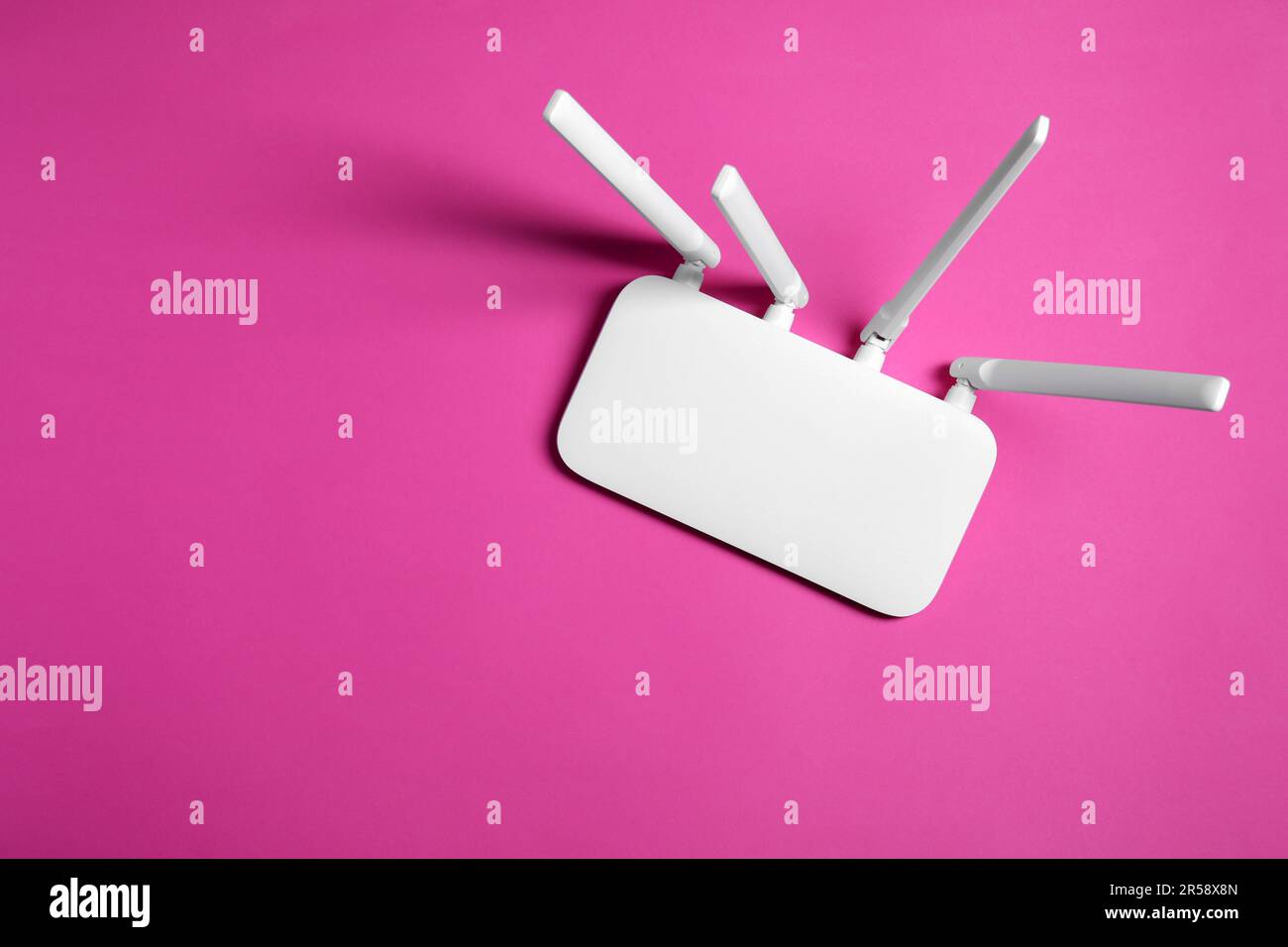 New white Wi-Fi router on pink background, top view. Space for text ...