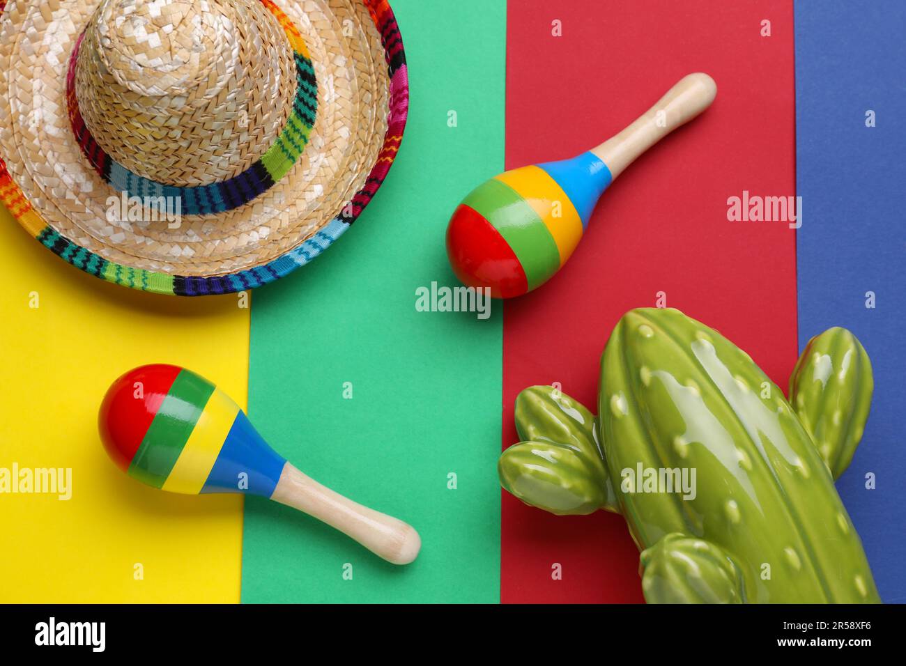 Maracas, toy cactus and sombrero hat on colorful background, flat lay ...