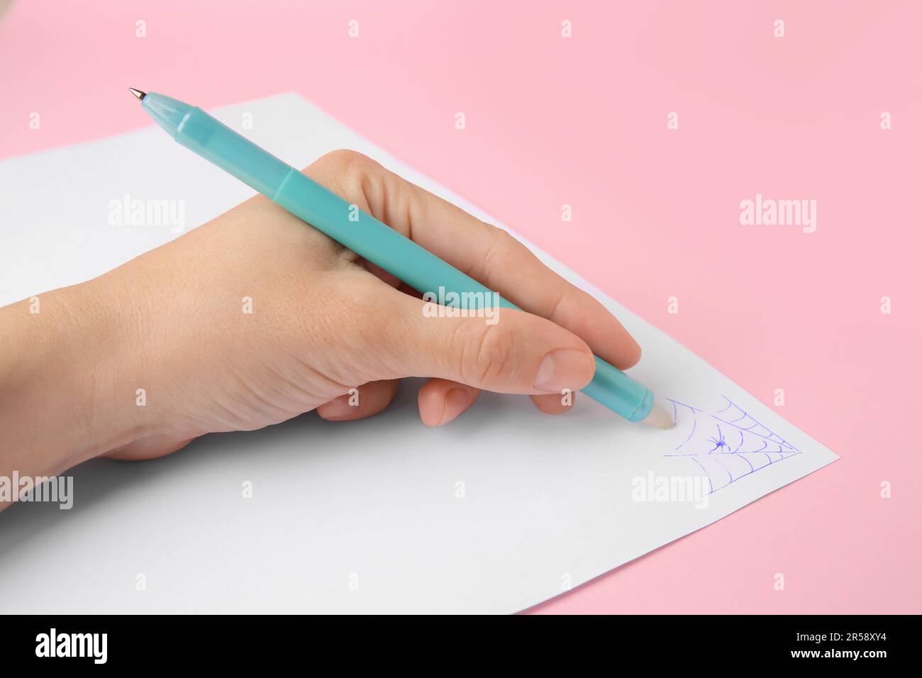 Woman erasing web drawn with erasable pen on sheet of paper against ...