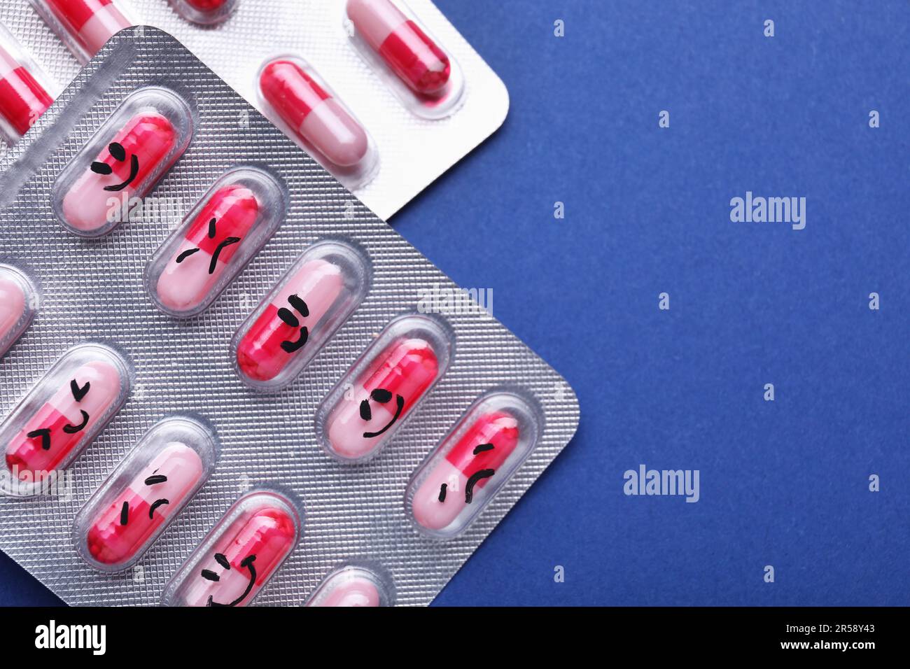 Blisters of antidepressant pills with emotional faces on blue ...