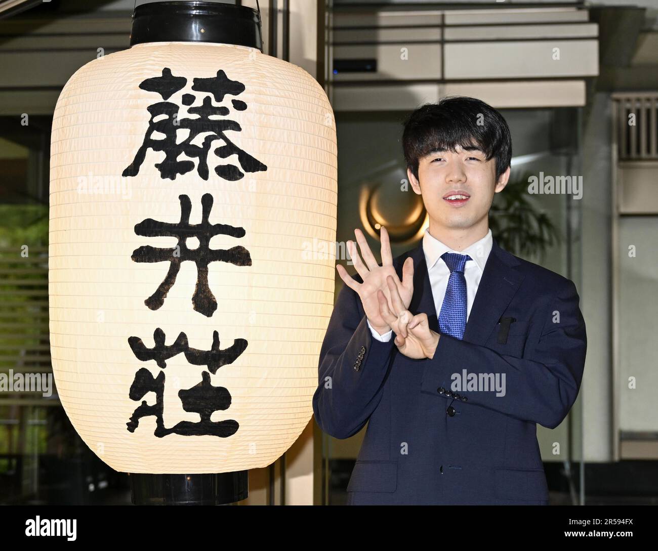 Shogi player Sota Fujii poses in front of a paper lantern with the ...