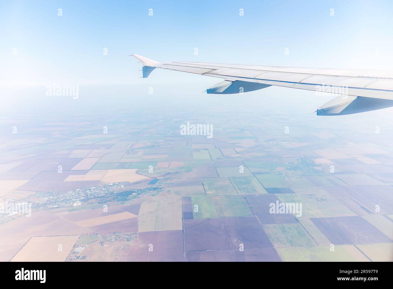 Aerial view from airplane window above green ground. View from the ...