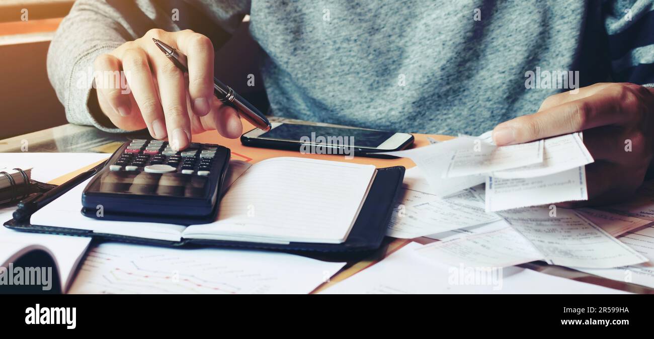 Man using calculator and calculate bills in home office Stock Photo - Alamy