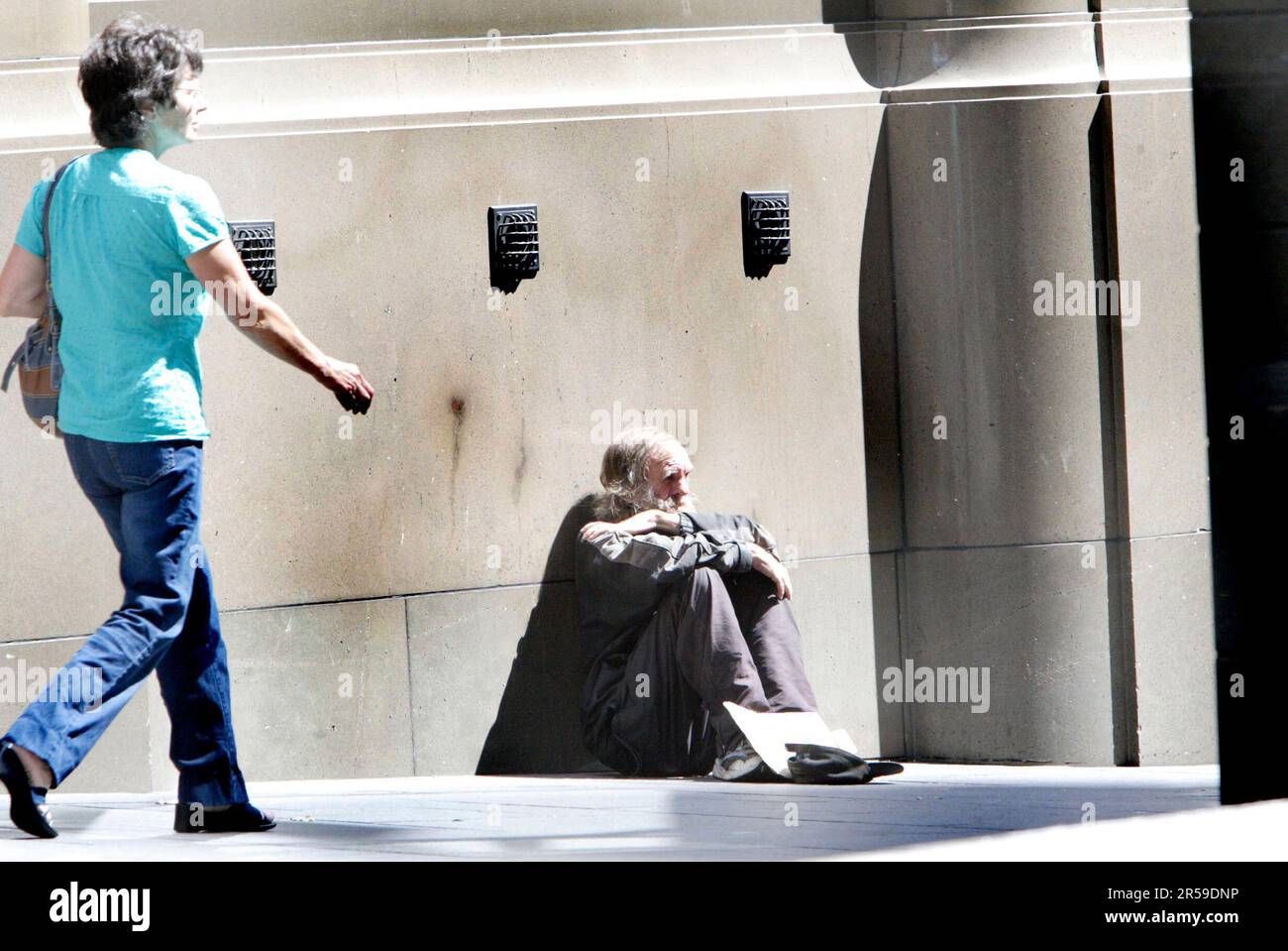 A homeless man begs with the aid of a placard in Martin Place in Sydney ...