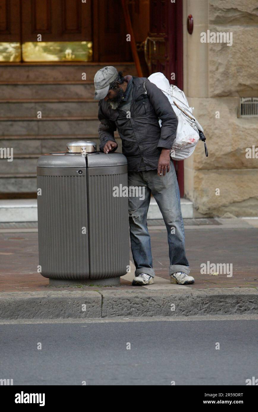 A homeless man rummages through a garbage bin on Macquarie Street in ...