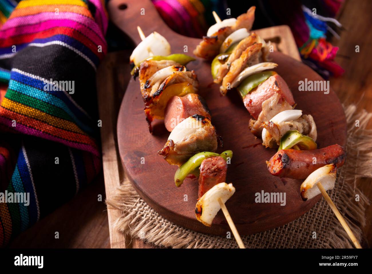 Homemade Skewers with meat and grilled vegetables served on a rustic wooden board, also known as ...