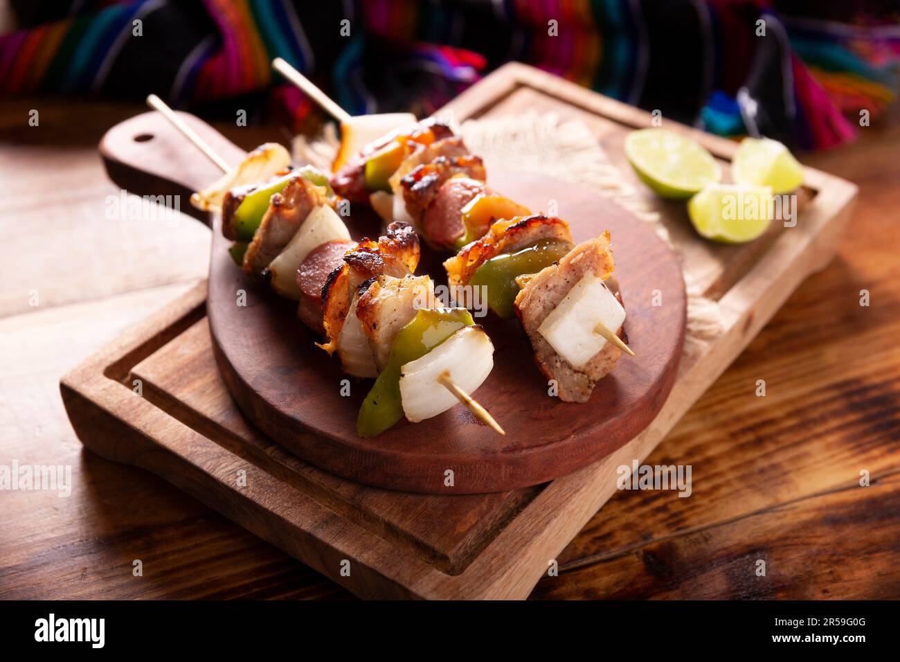Homemade Skewers with meat and grilled vegetables served on a rustic wooden board, also known as ...