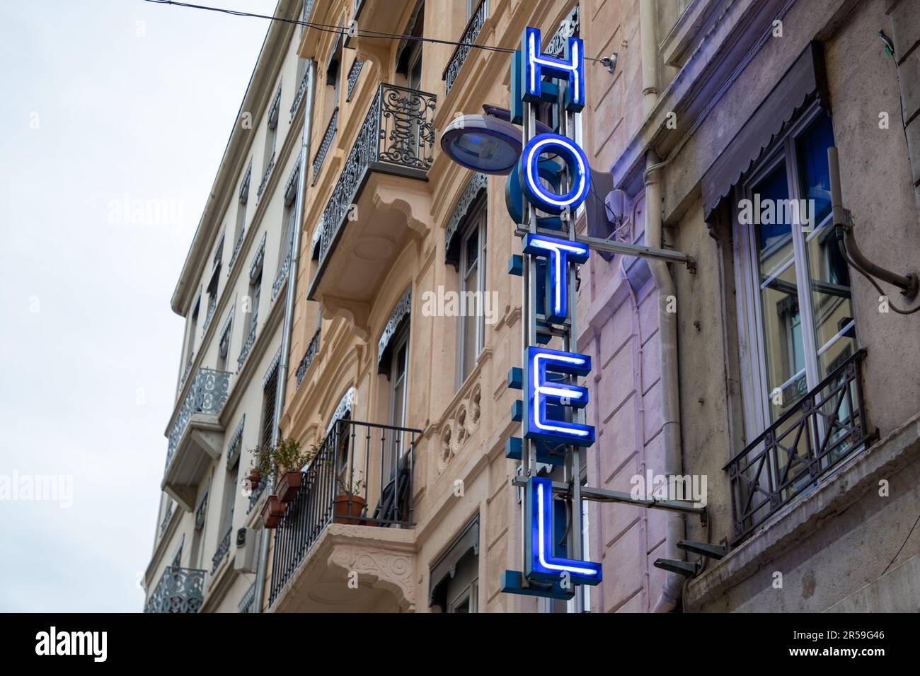 Hotel sign blue neon text in wall building facade in tourist city Stock ...