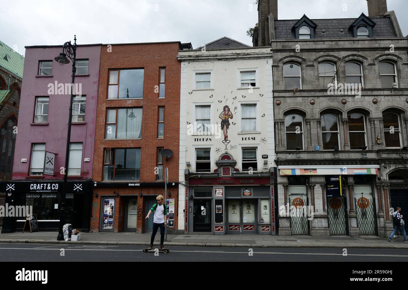 A young Irish man skateboarding infront of the Thomas House on Thomas ...