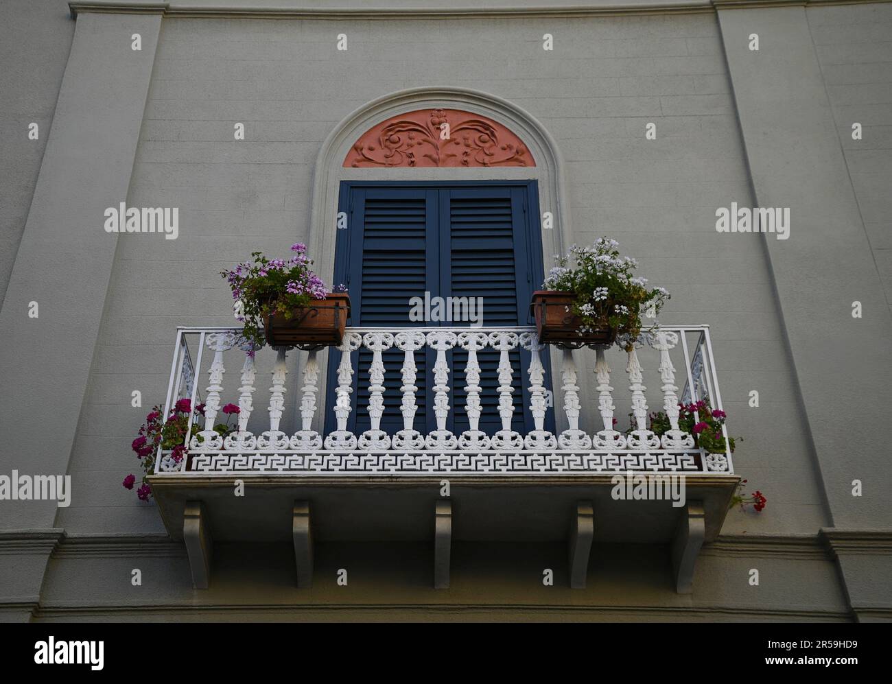 Traditional house facade with an arched window, wooden shutters and a ...