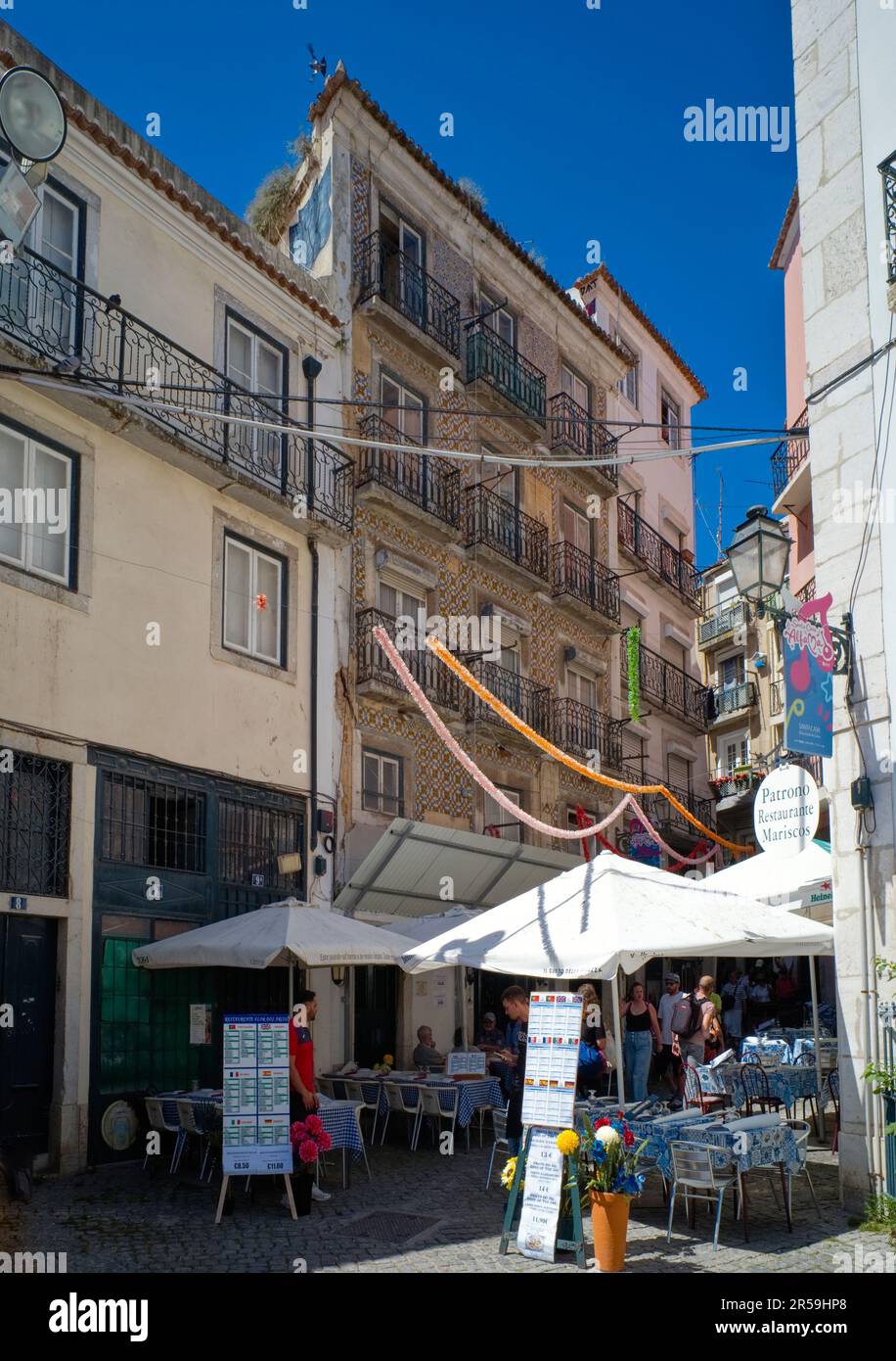 Restaurants either side of a narrow pathway in the Alfama district of ...