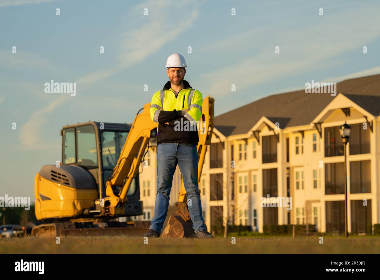 Builder in a construction site. Builder with excavator ready to build ...