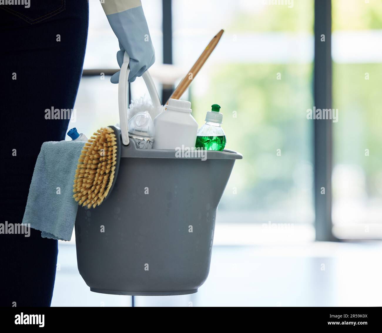 Hands, cleaner and bucket of supplies for cleaning, hygiene or ...
