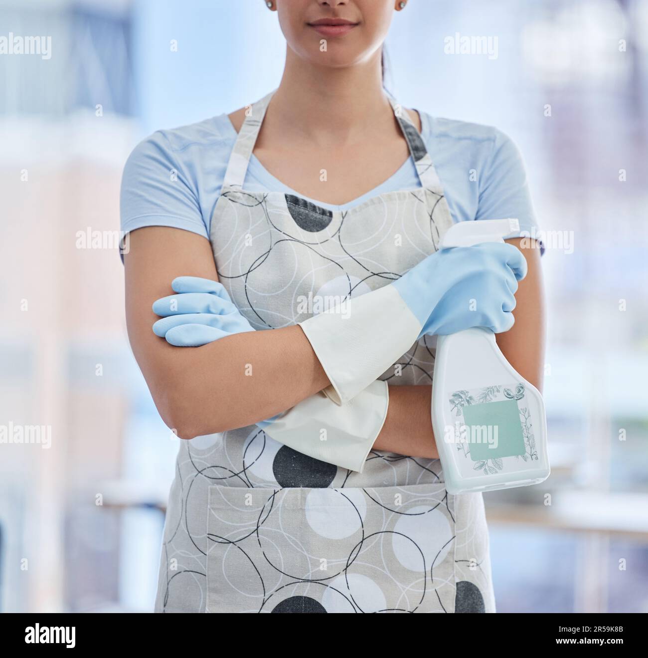 Woman, housekeeper and gloves with detergent for cleaning, hygiene or ...