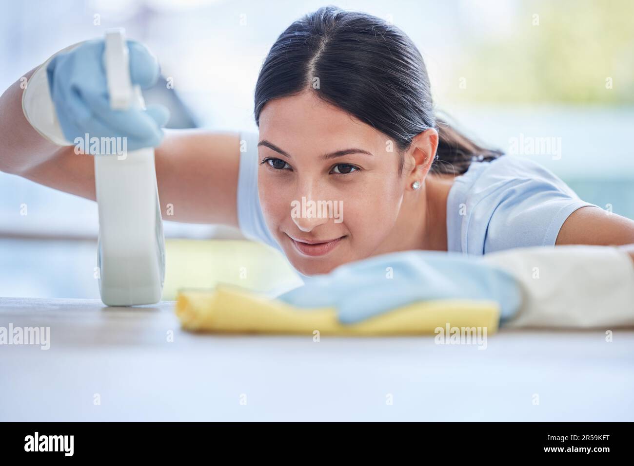 Woman, housekeeper and detergent for cleaning table, hygiene or ...