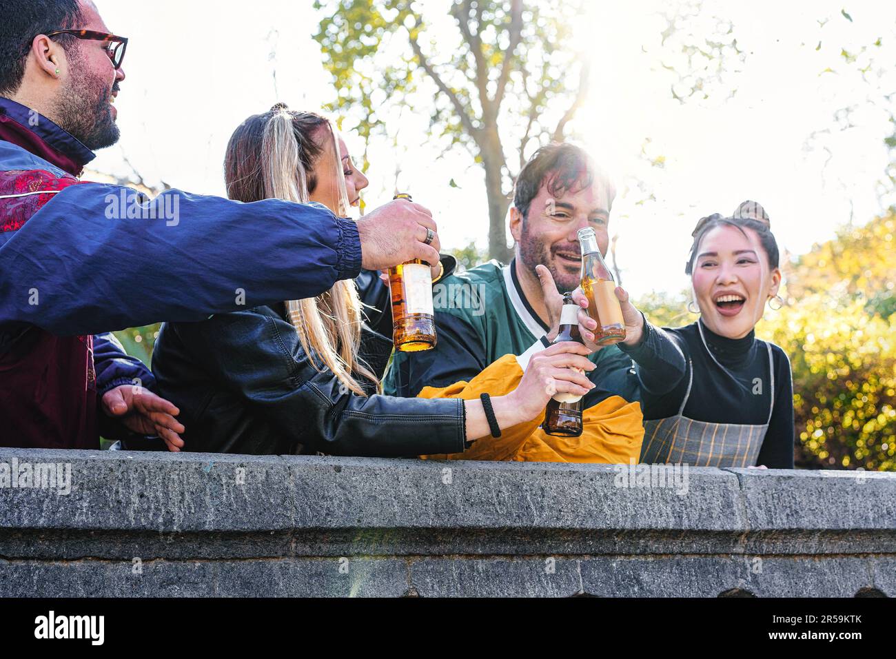 Caucasian and Asian friends gathering on a stone balcony in a public ...