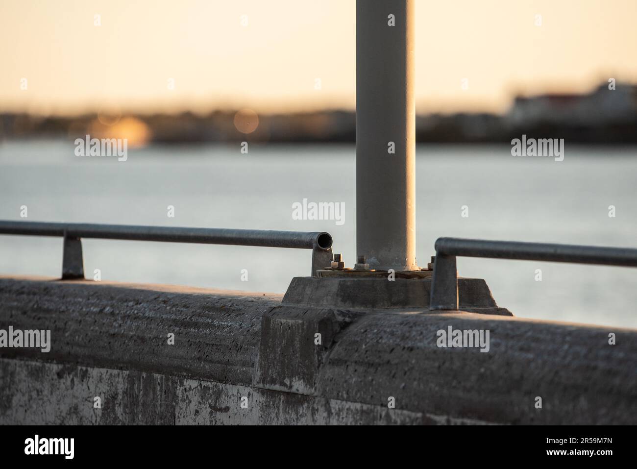 Metal railings around a pole mounted in a concrete barrier Stock Photo ...
