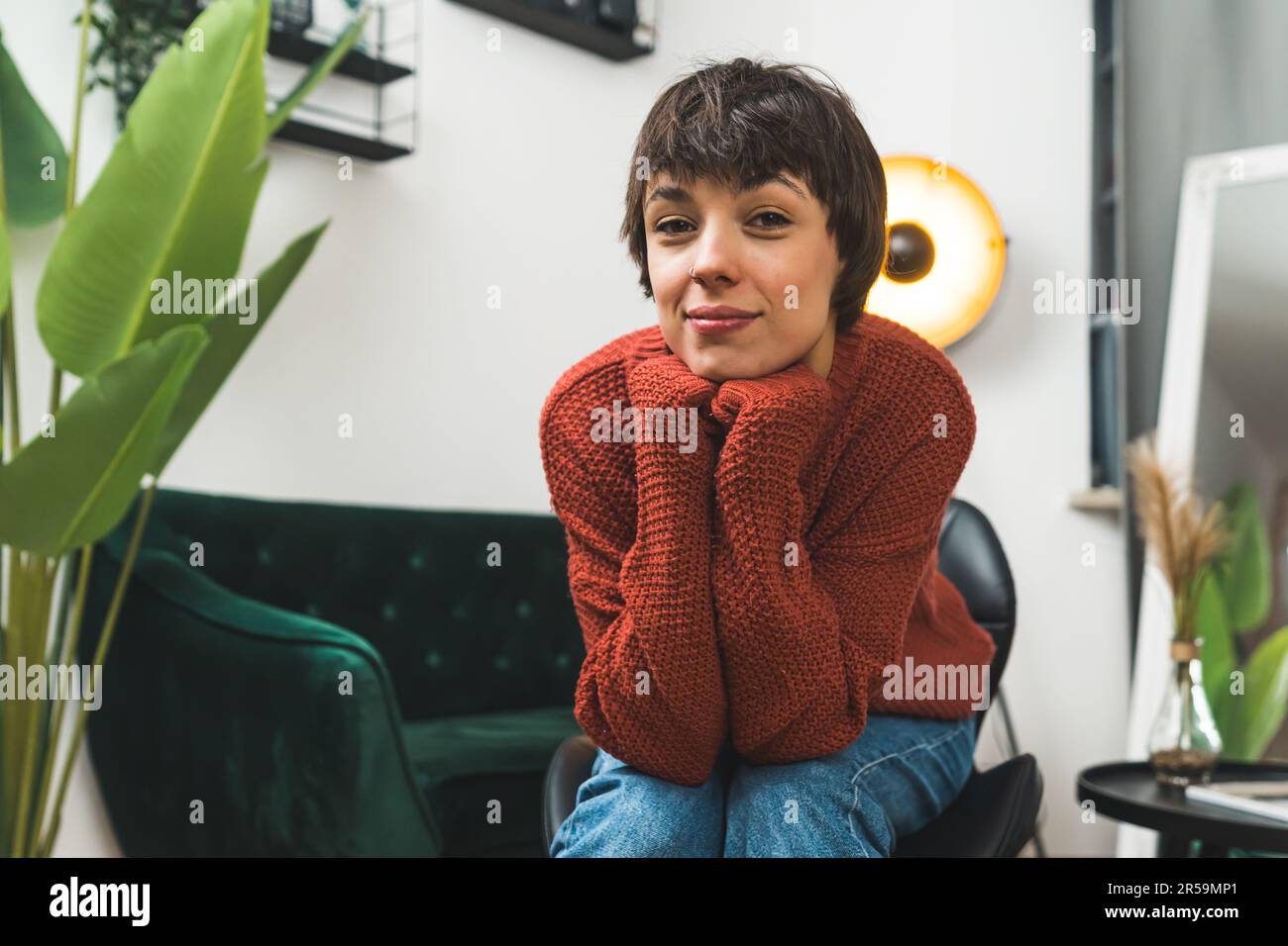 Young woman with a mysterious expression looking at the camera and ...