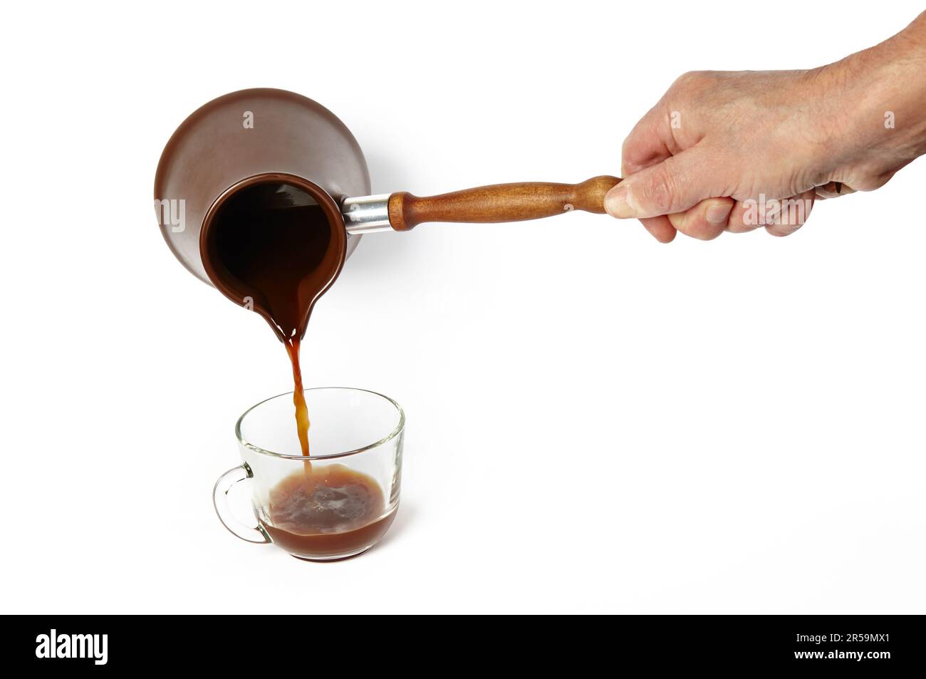 Man pouring coffee into cup isolated white background. Clay cezve for ...
