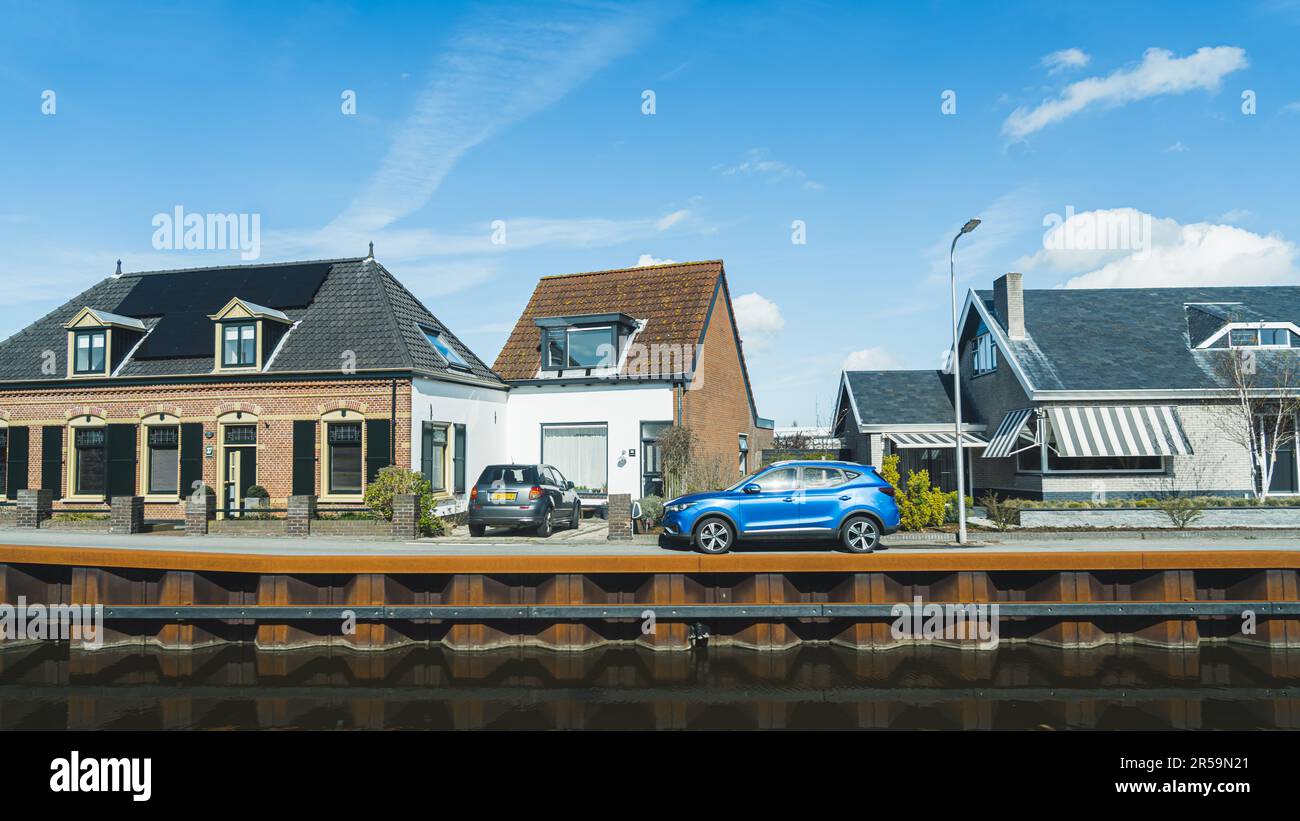 Dutch mansion with cars near the canal in the Netherlands. Summer ...