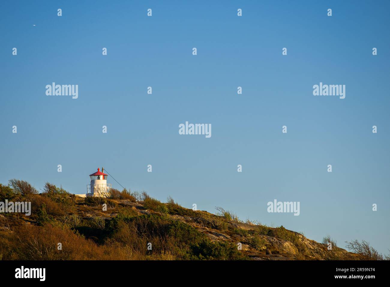 Small lighthouse on top of a windy cliff Stock Photo - Alamy
