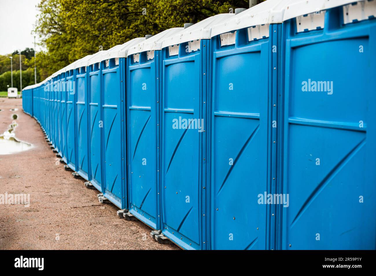 Long row of blue portable toilets Stock Photo - Alamy