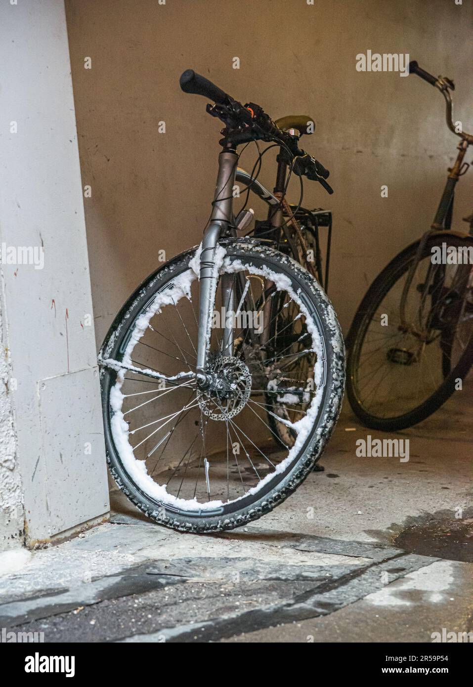 Snowy, grey bike parked in an alley Stock Photo - Alamy