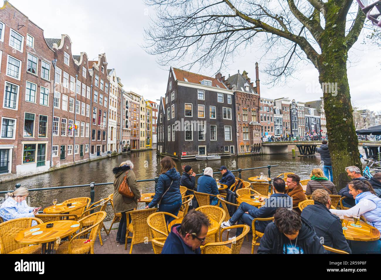 Tourists and Dutch people enjoying coffee on the bank of Amsterdam ...