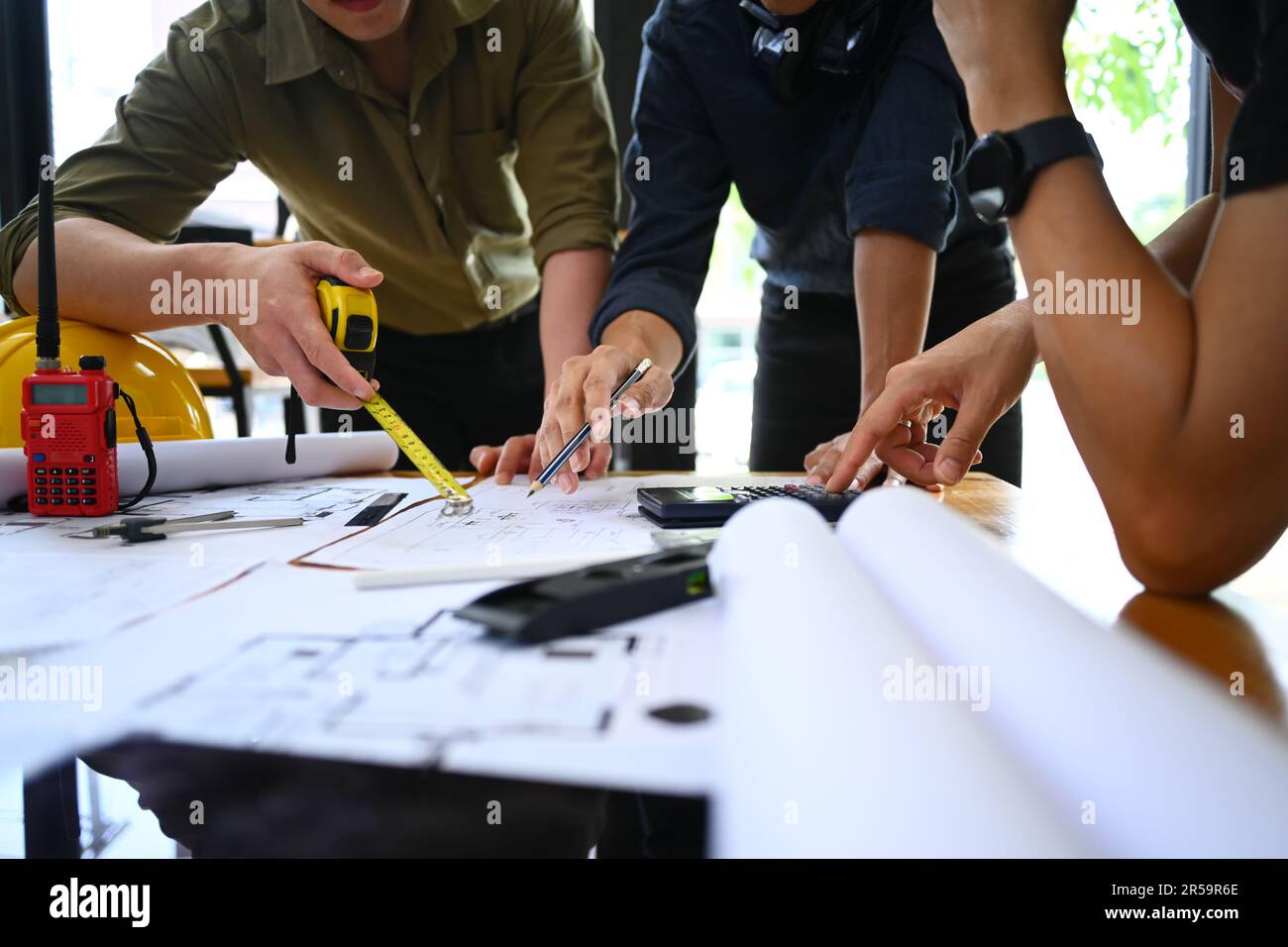 Architect team working with blueprints, planning development details ...