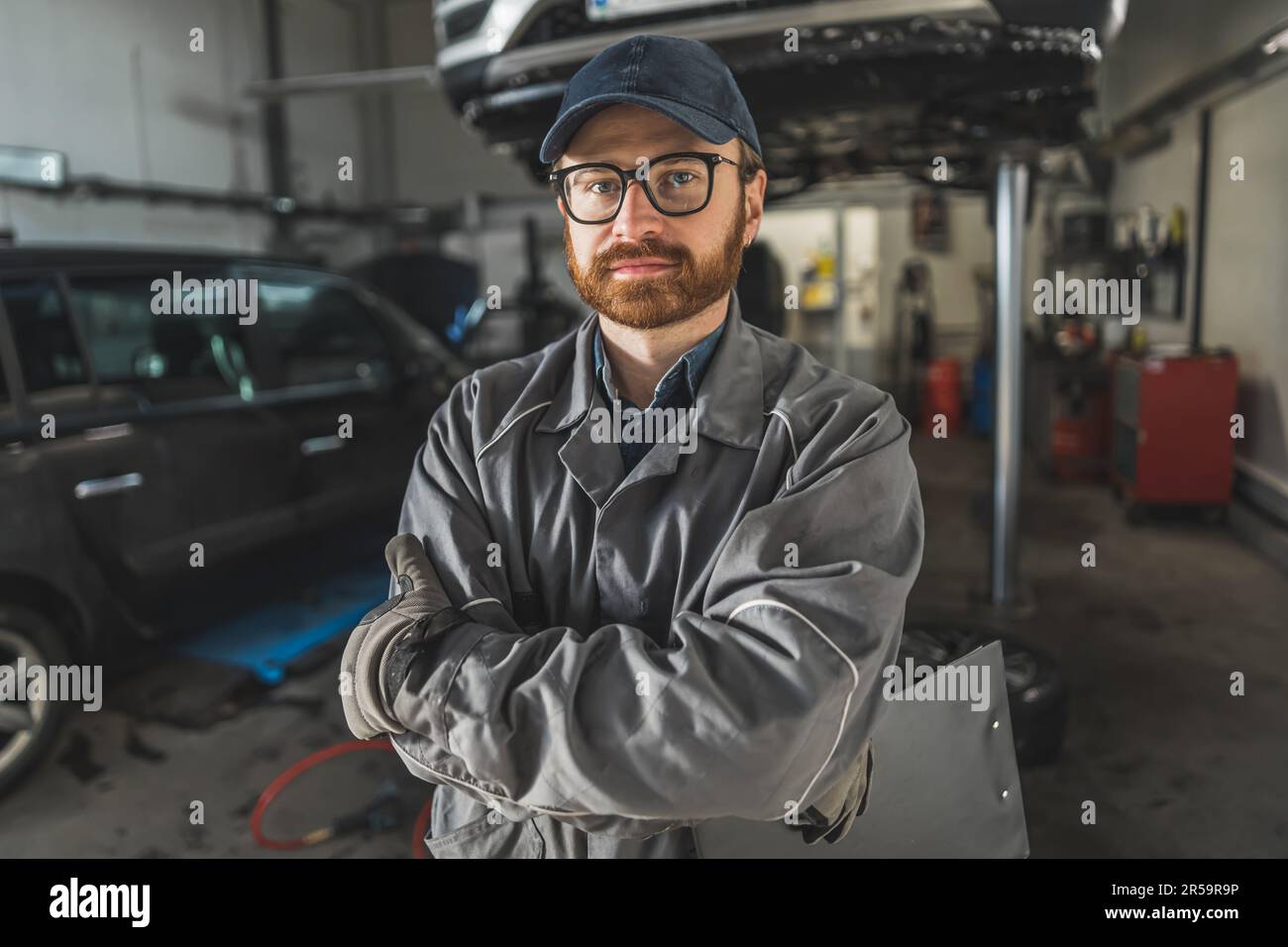 Portrait of a bearded man car mechanic with his arms crossed in repair ...