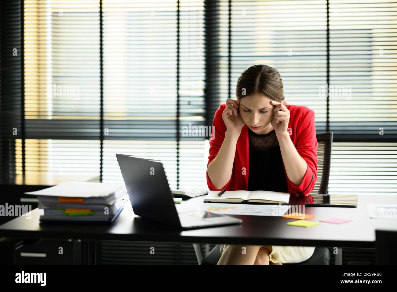 Stressed female manager holding her head, tired from work, having ...