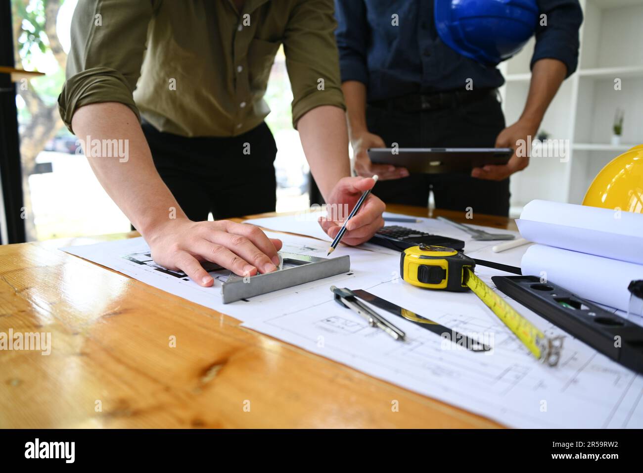 Team of engineers standing at meeting table, discussing construction ...