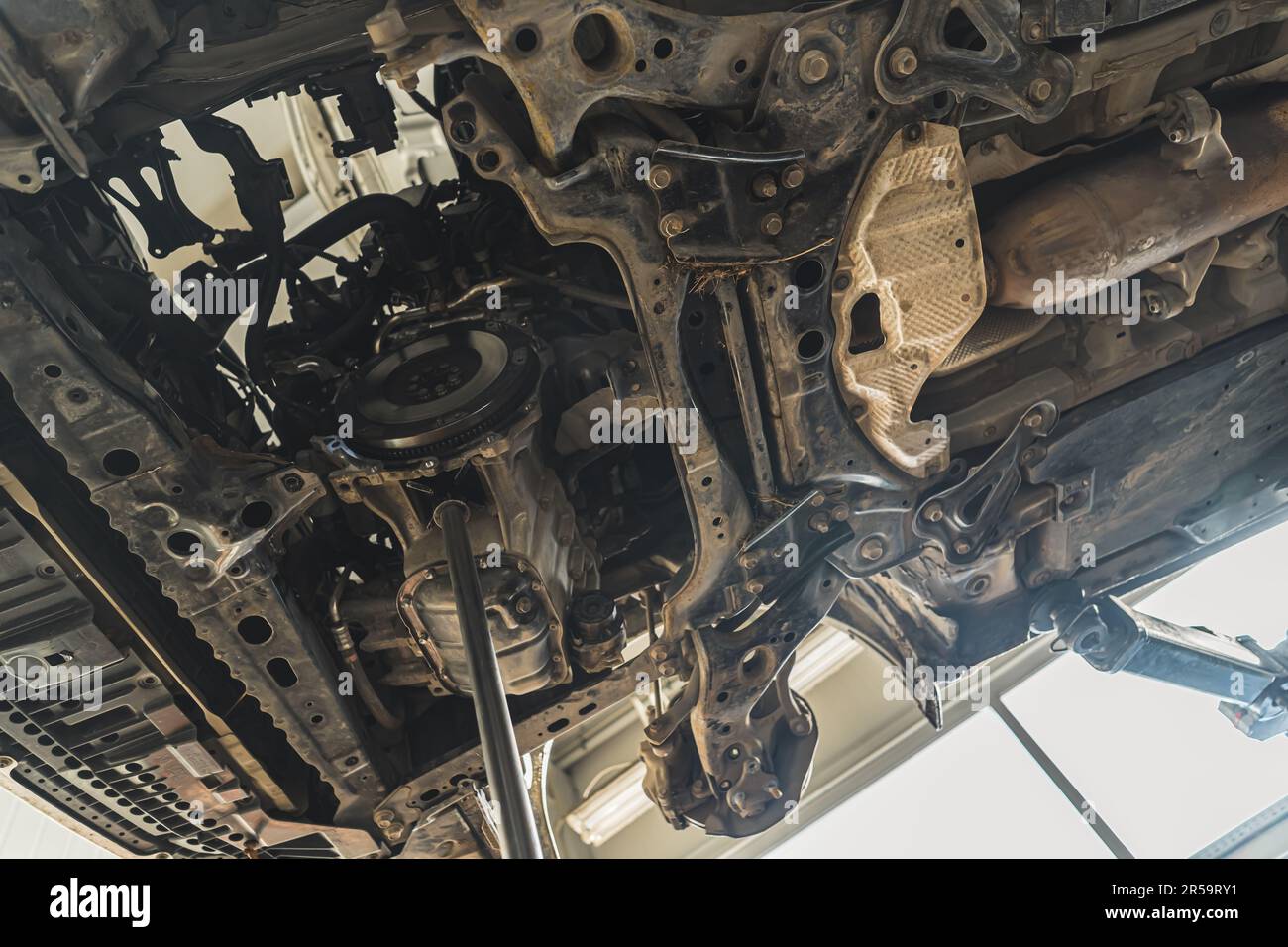 A car raised on a lift for repair, with flywheel seen. High quality ...