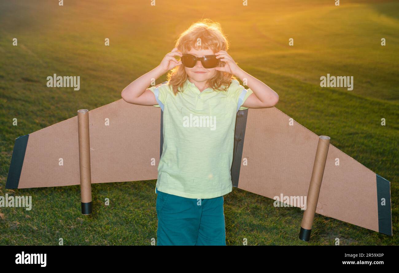 Child boy playing with toy cardboard wings. Kid dreams of future. Kid ...