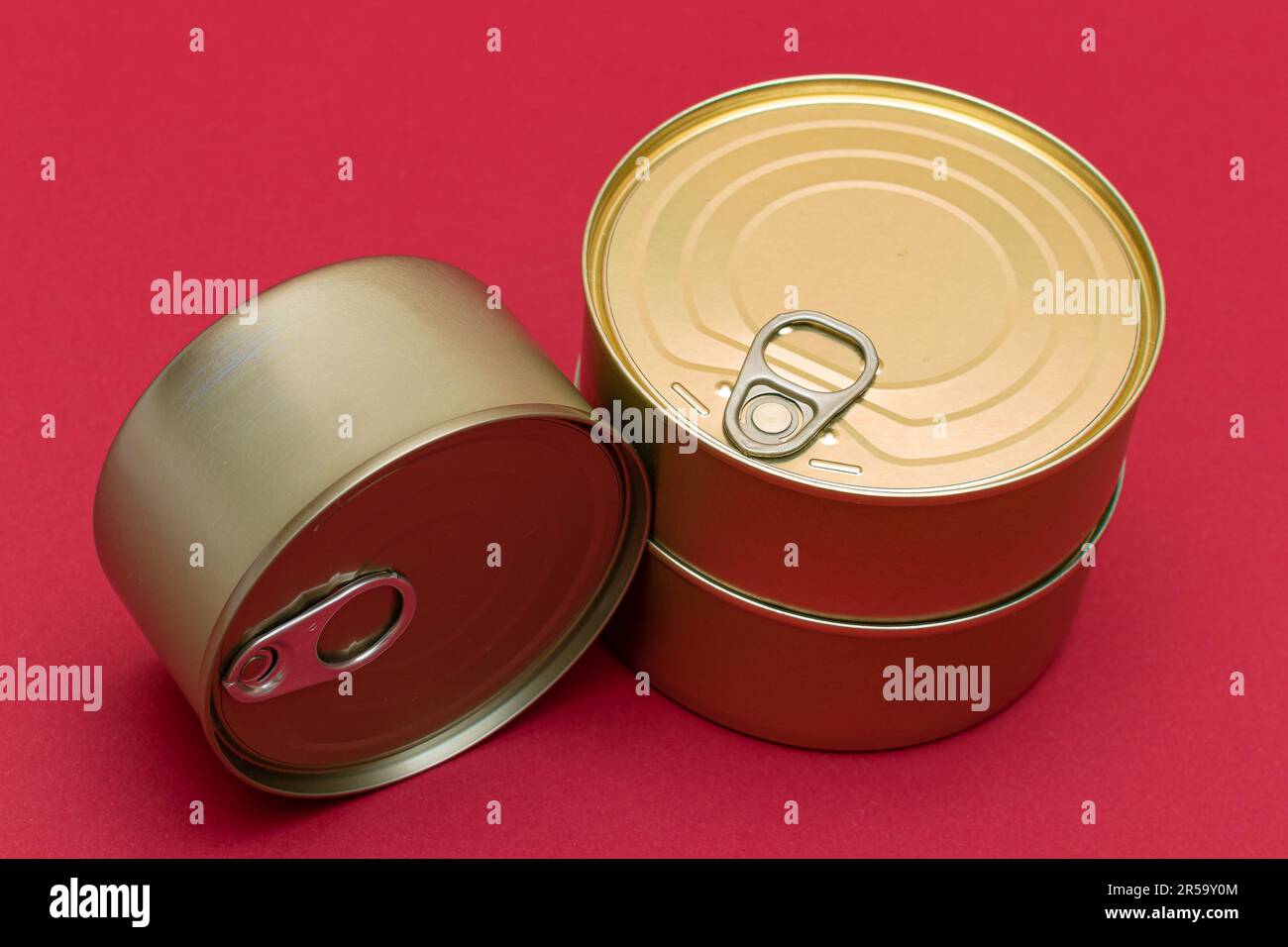 A Group of Stacked Tin Cans with Blank Edges on Red Background. Canned ...