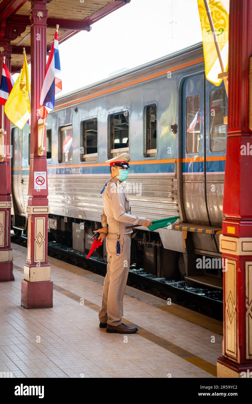 A Thai train guard stands on the platform of Hua Hin Train Station ...