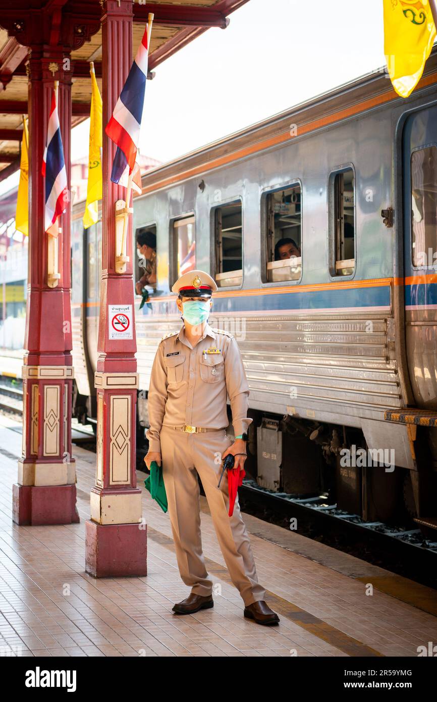 A Thai train guard stands on the platform of Hua Hin Train Station ...