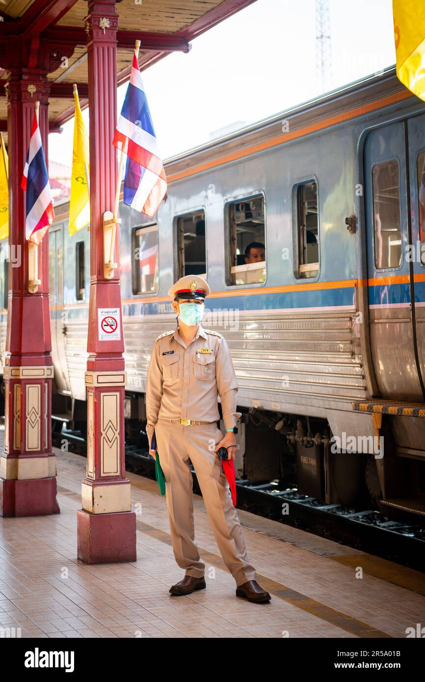 A Thai train guard stands on the platform of Hua Hin Train Station ...