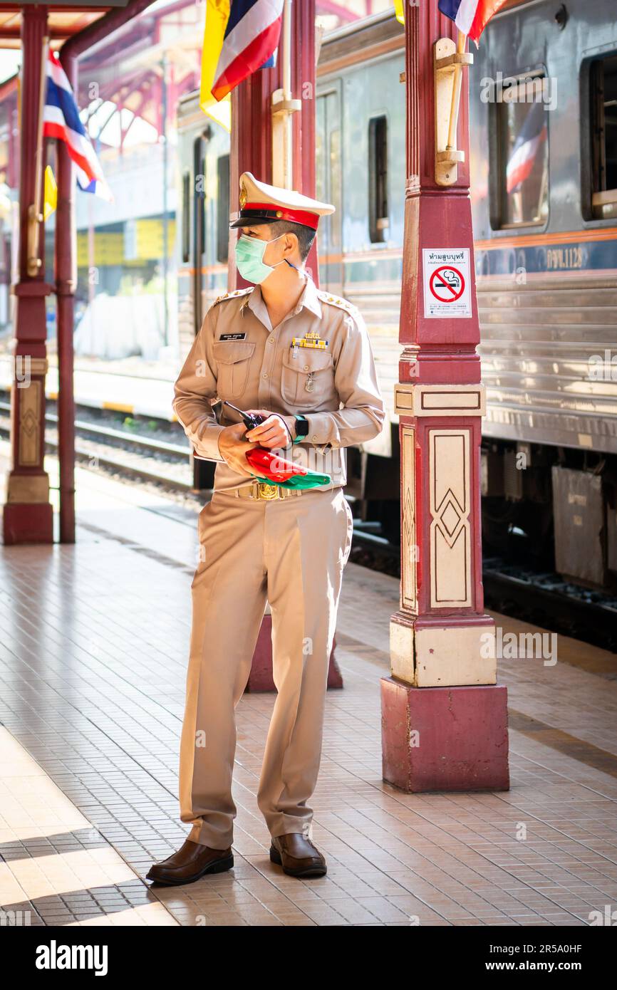 A Thai train guard stands on the platform of Hua Hin Train Station ...