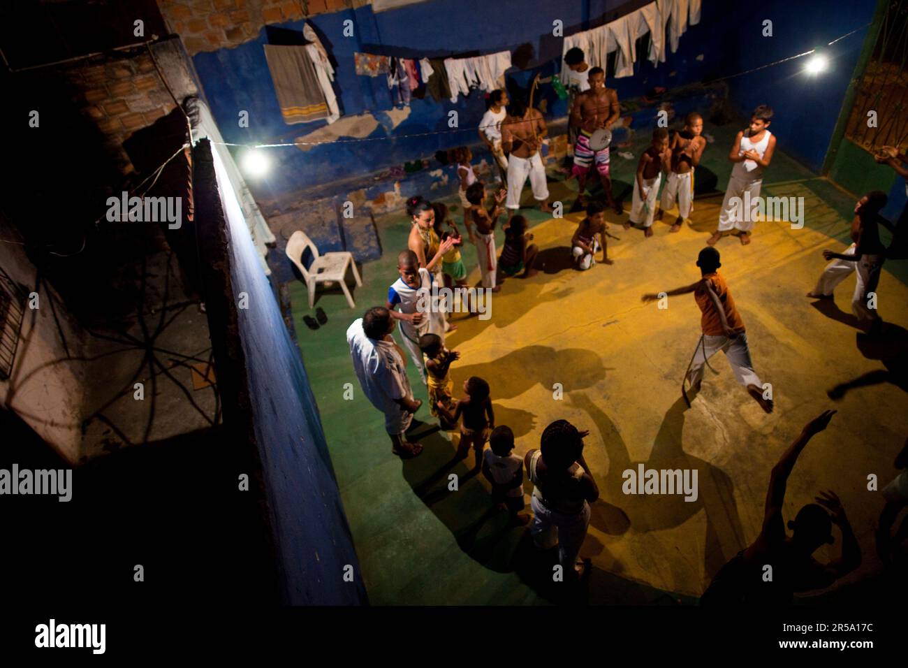 Young capoeiristas practice their moves during a roda in an outdoor ...