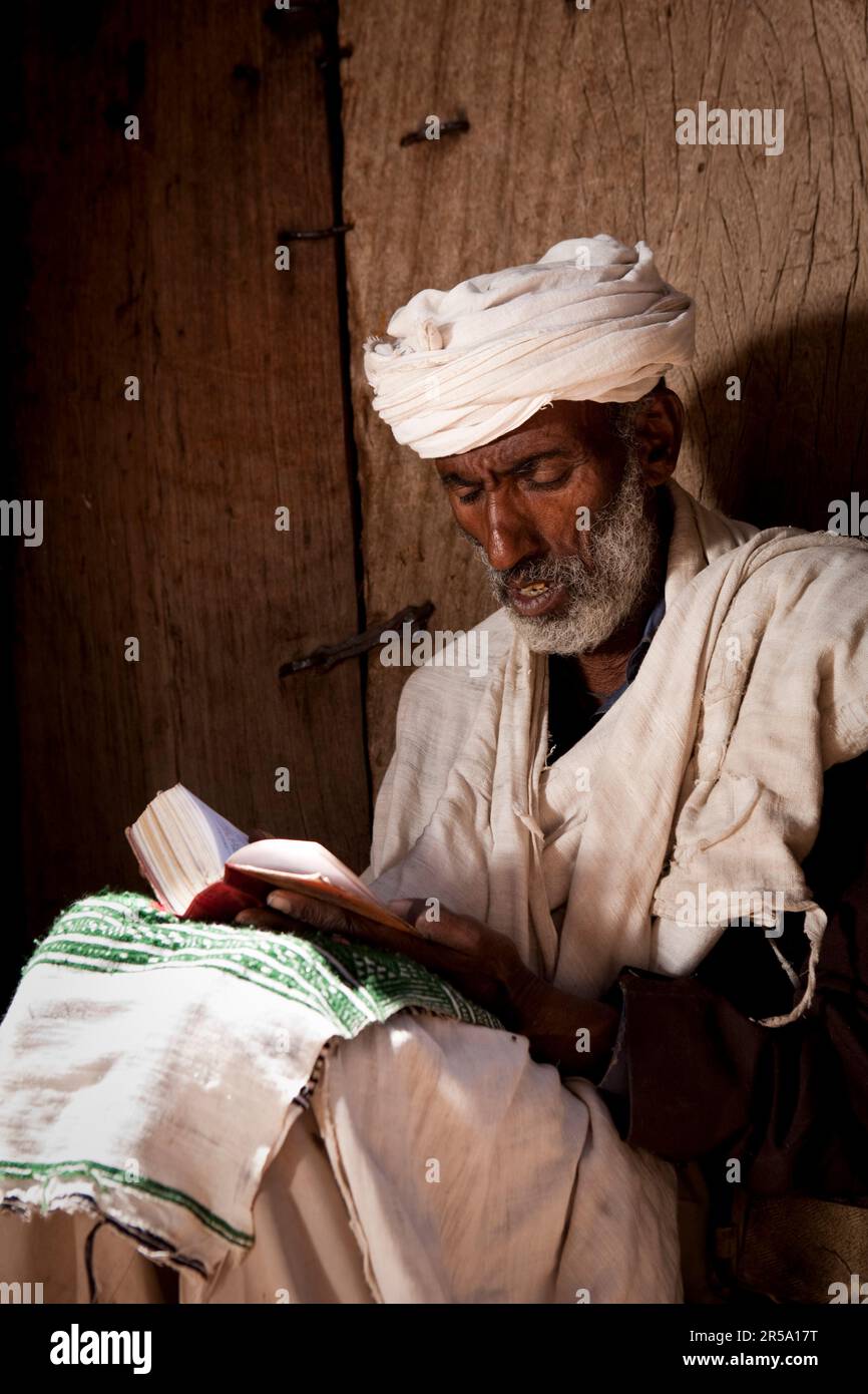 An Orthodox Christian man reads from the bible at Bet Medhane Alem ...